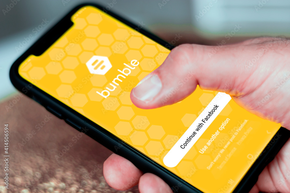 the thumb of a male hand while touching the green screen of a mobile ...