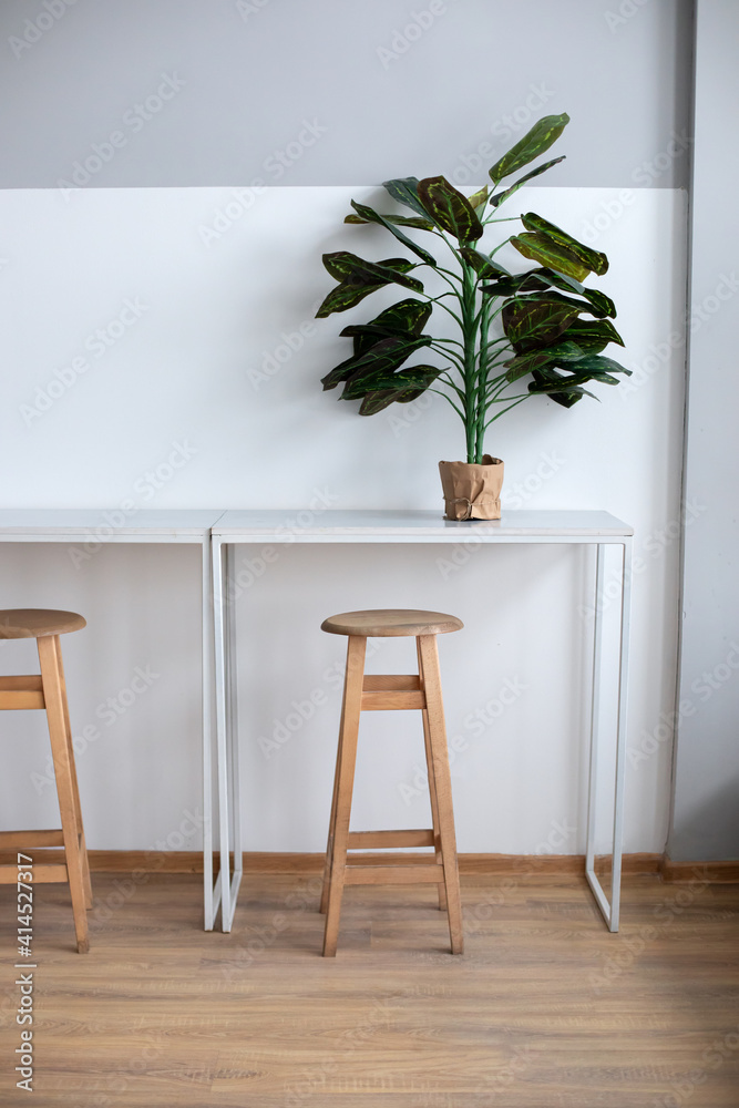 Simple Sitting area with table, high chairs and plant in pots ...