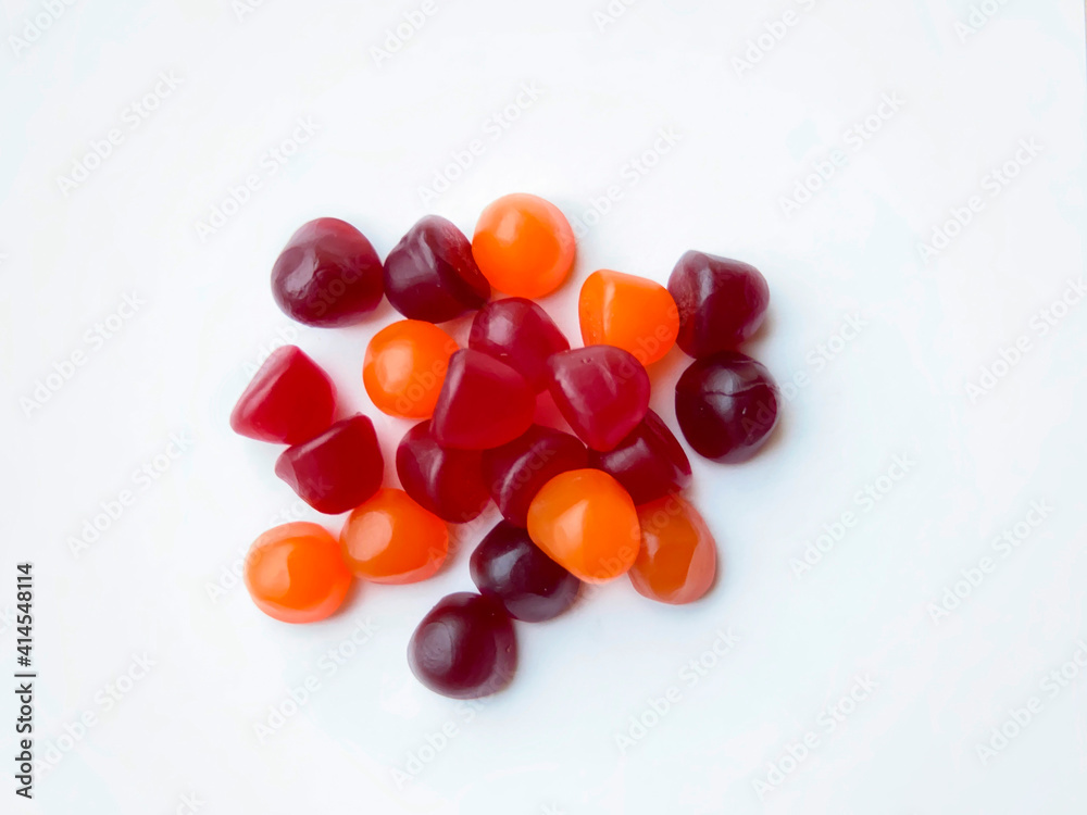 Group of red, orange and purple multivitamin gummies isolated on white ...