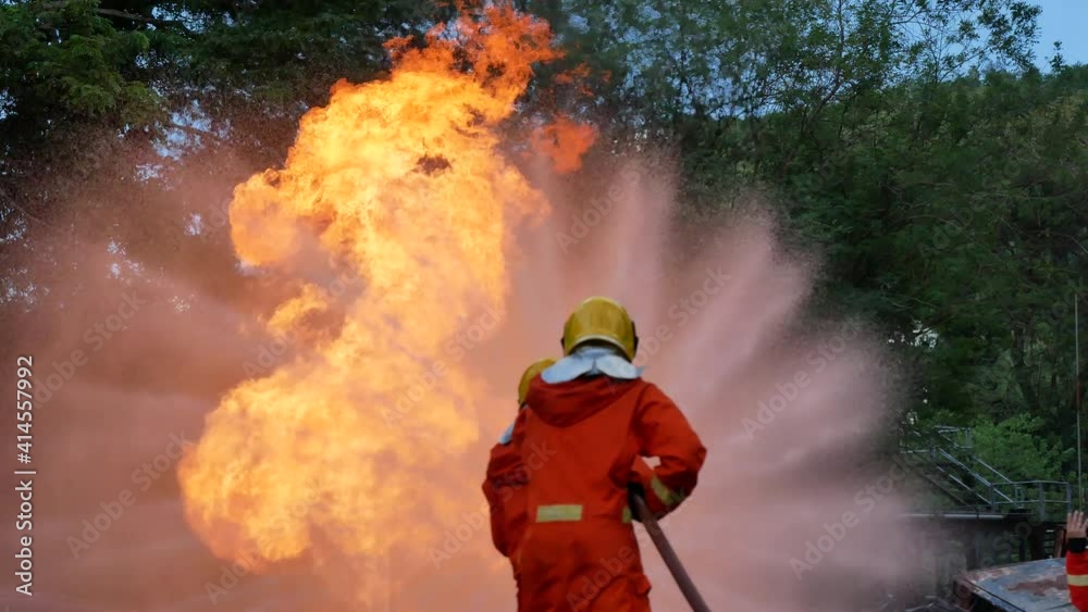 Firefighter fighting with fire flame protection property. Fireman wear ...