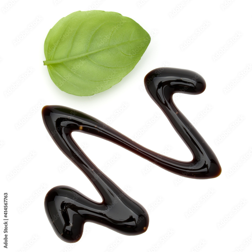 Balsamic vinegar cream and basil leaves isolated on white background ...