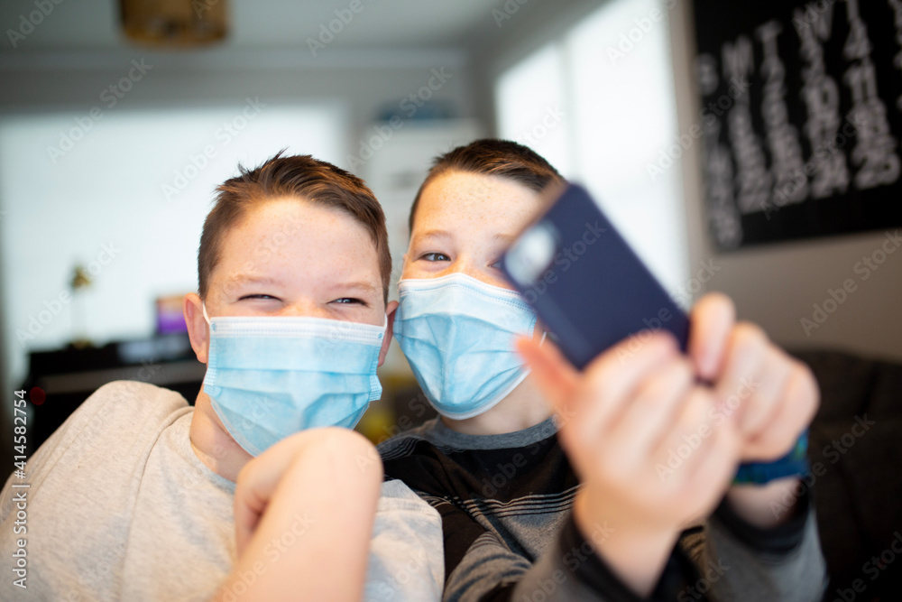 two boys in masks taking selfies Stock Photo | Adobe Stock