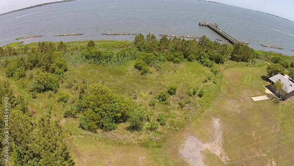 Drone shot tracks along shoreline showing fishing pier and Delaware ...