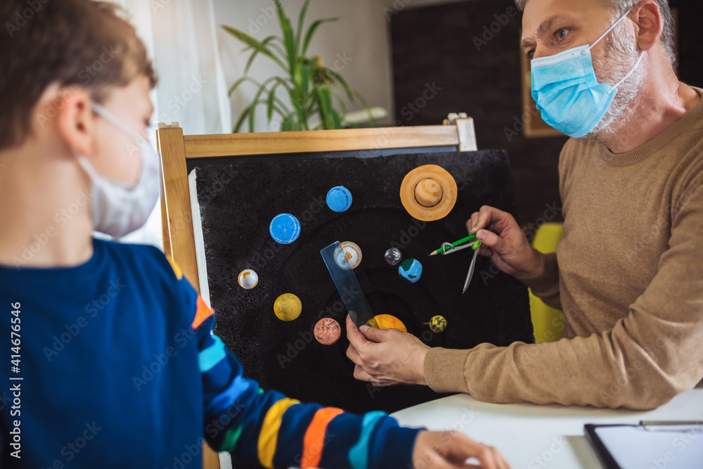 Happy school boy and his father making a solar system for a school ...