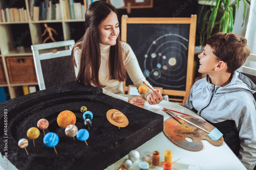 Happy school boy and girl making a solar system for a school science ...