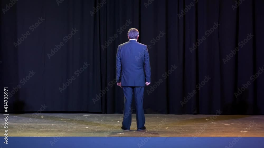 a politician stands on stage with his back to the world the image from ...