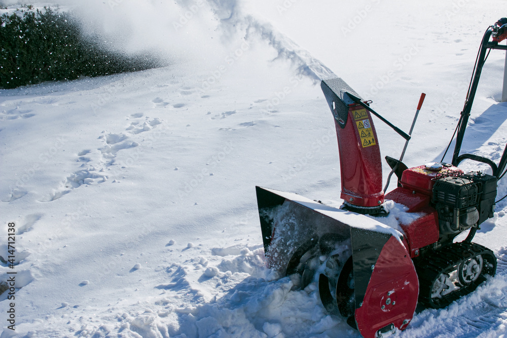 Tracked snow blower at work. After heavy snowfalls, snow is removed ...