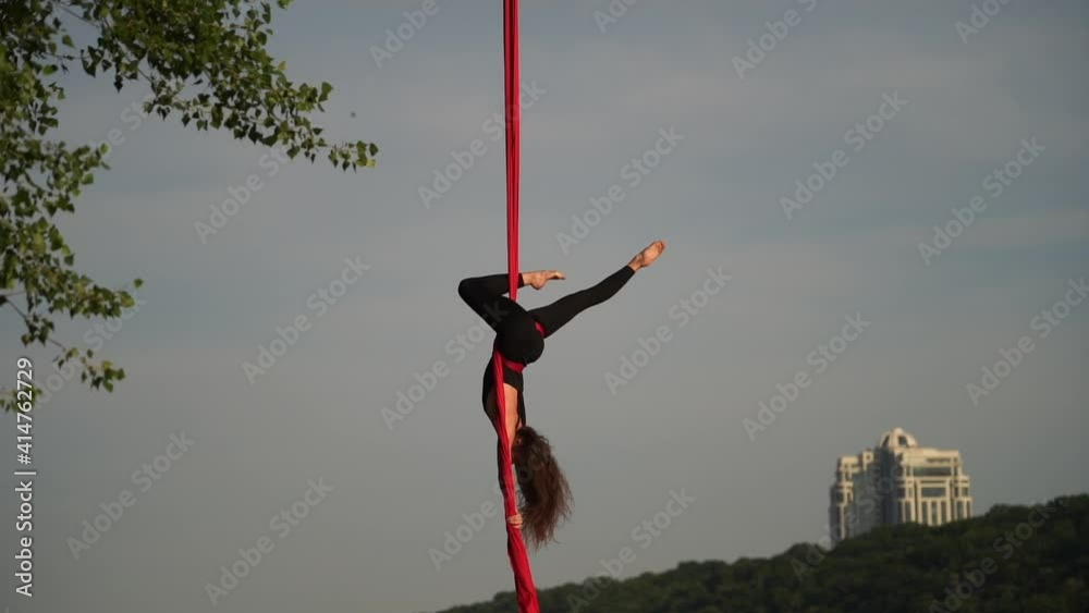 Stockvideon Female acrobat showing her flexibility and splits with red ...