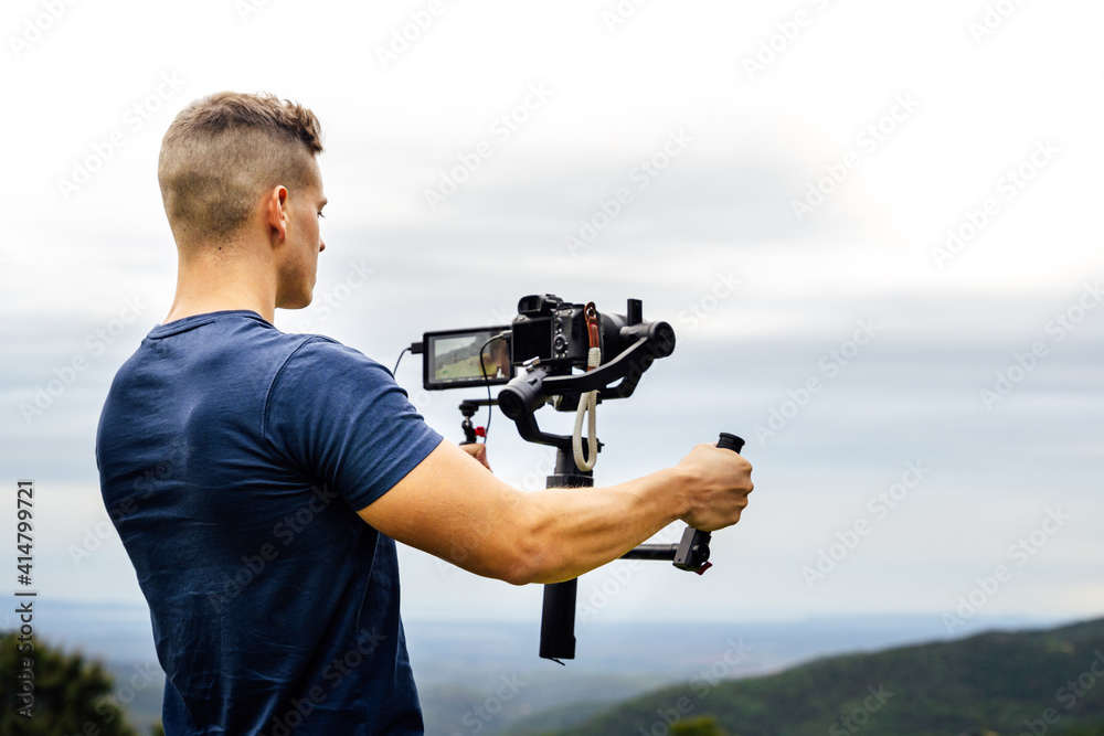 Foto de Young muscular Caucasian man manning a camera on top of a ...