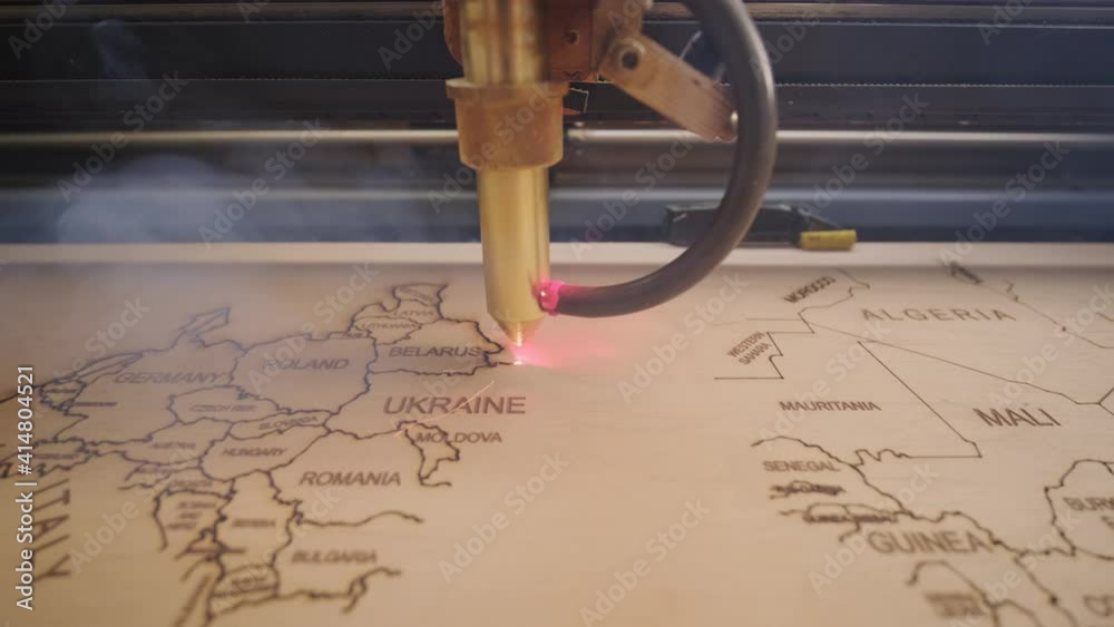 Cnc laser cutting machine cuts world map on wooden plank and plywood ...