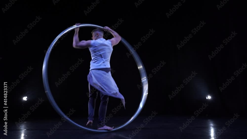 Male muscular acrobat shows difficult tricks for a balance and ...