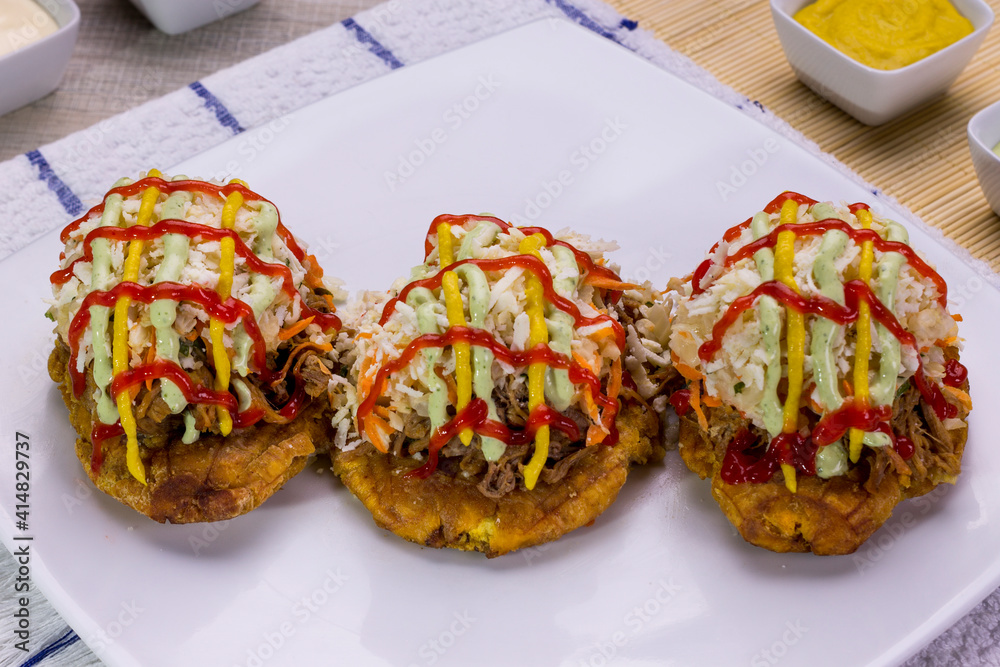Plato de comida venezolana hecho de tostón con ensalada de col, queso ...
