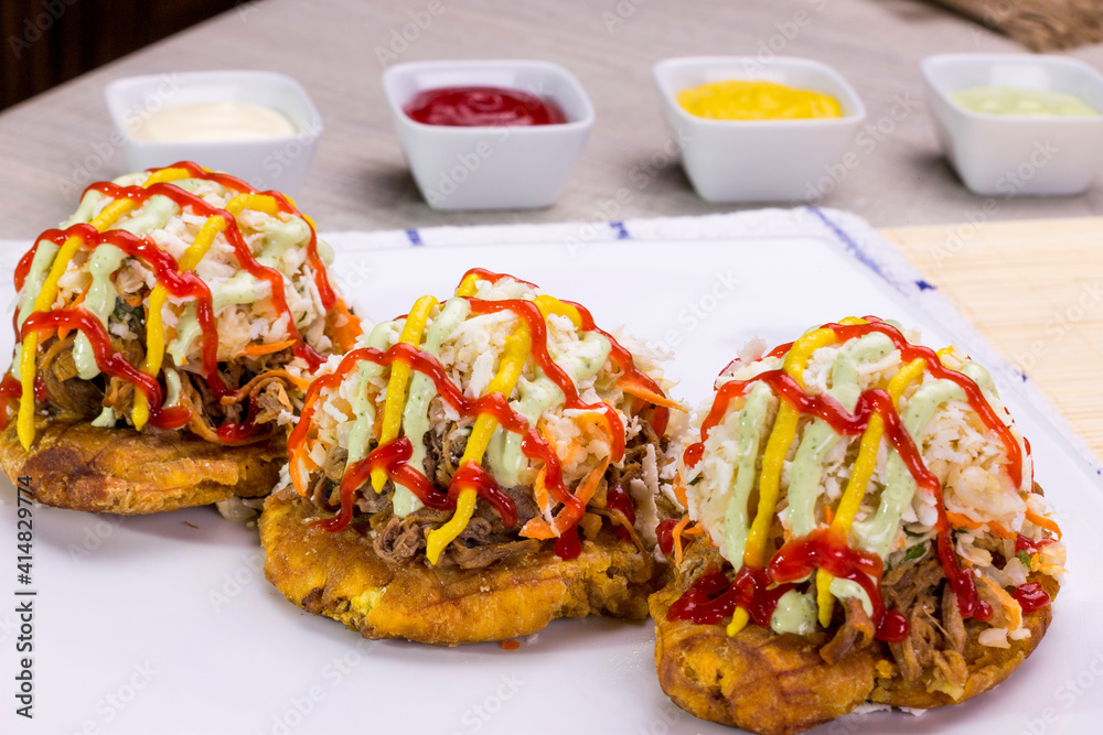 Plato de comida venezolana hecho de tostón con ensalada de col, queso ...