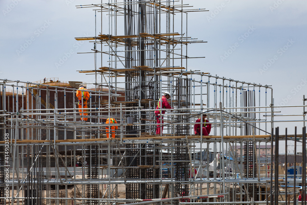 Fotka „Industrial climbers on assembling scaffolding. Oil refinery ...
