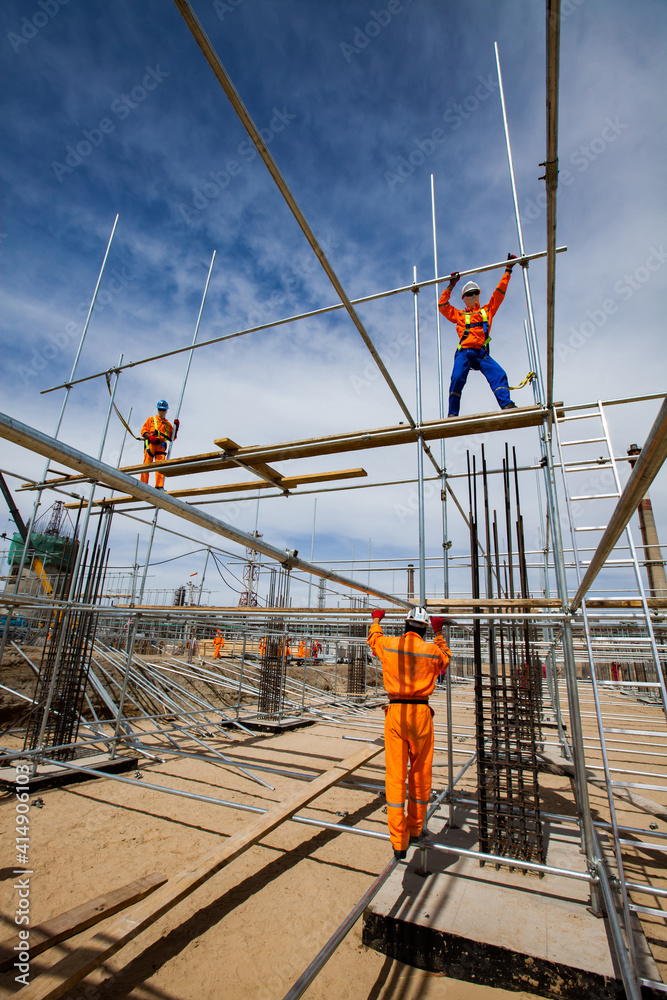 Industrial climbers on assembling scaffolding. Oil refinery plant ...