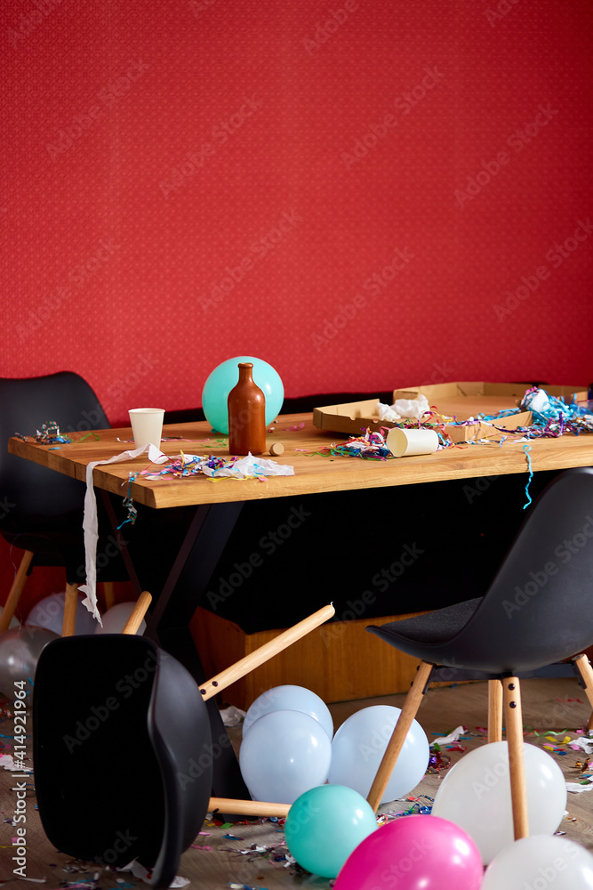 After party chaos, messy in livving room at home, table with pizza and ...