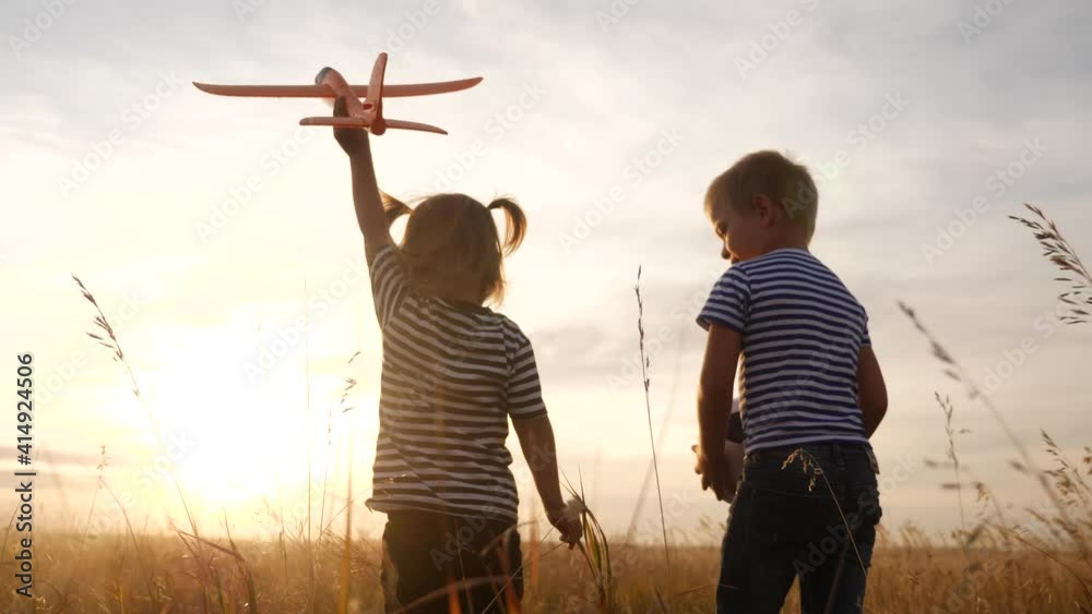 happy kids childs run with an airplane in the park. kid silhouette play ...