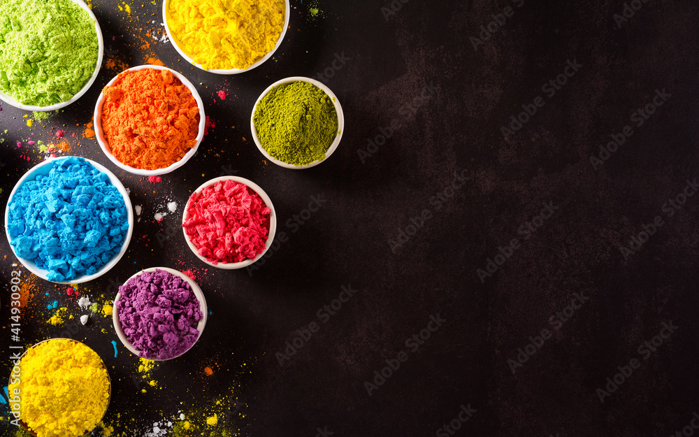 Happy holi festival decoration.Top view of colorful holi powder on dark ...