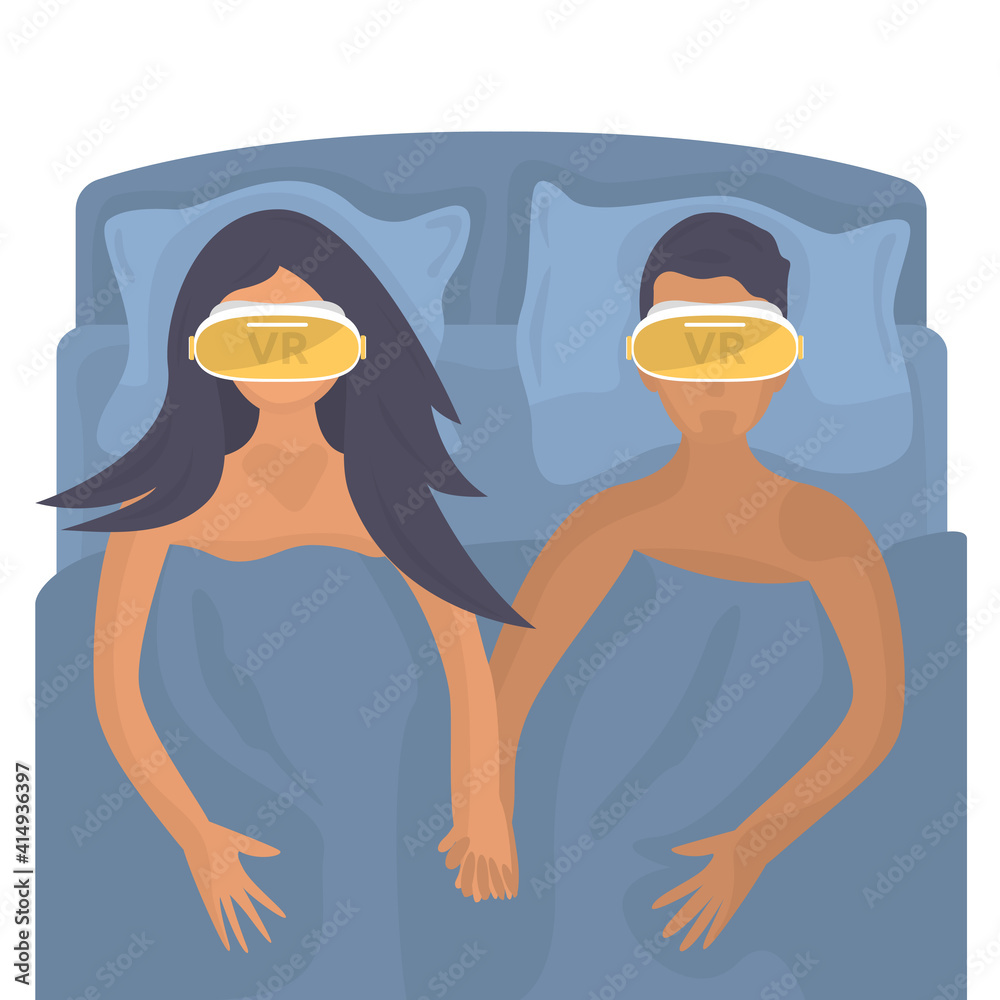 Man and woman lie in bed wearing virtual reality glasses. The couple ...