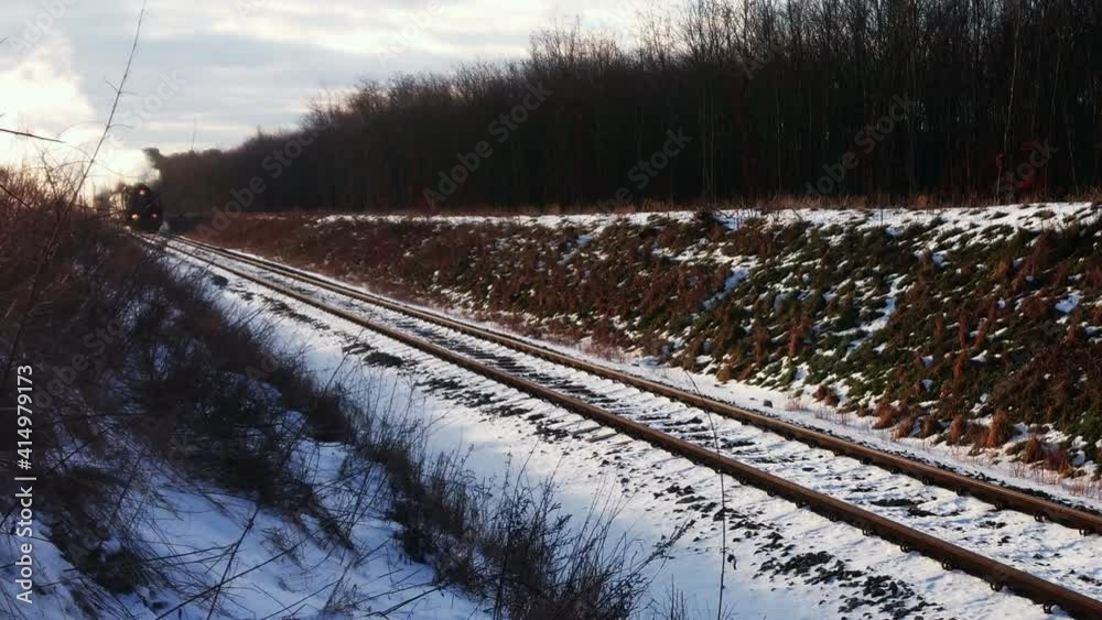Vintage steam locomotive with old wagons on snow-covered trail. Retro ...