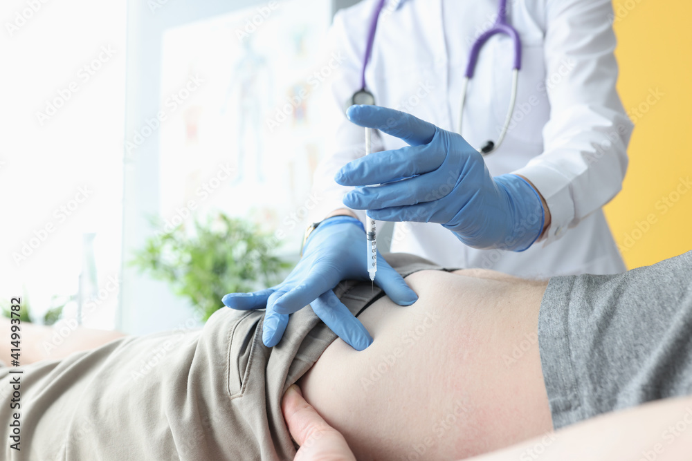 Nurse giving intramuscular injection of medicine into patients buttock ...