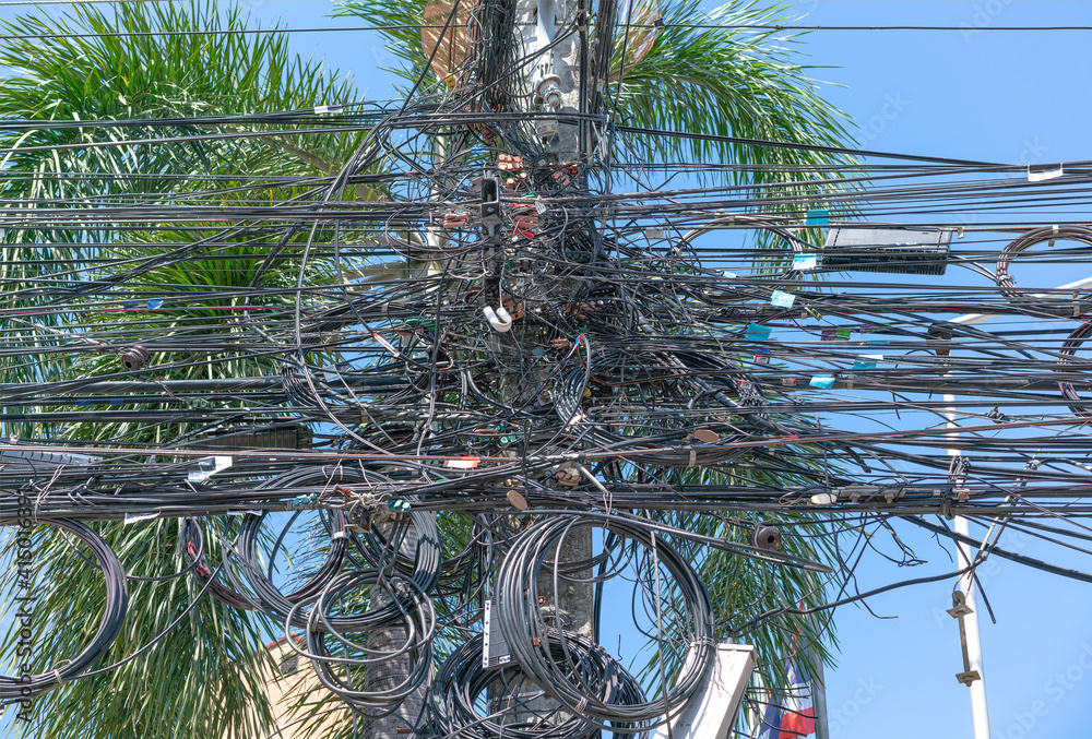 Chaos of cables and wires on an electric pole. Many electrical cable ...