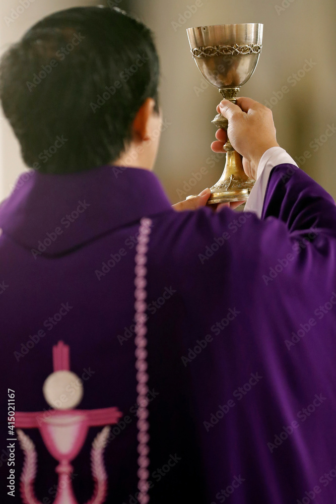 Priest wearing purple roman chasuble, Catholic Mass, Eucharist ...