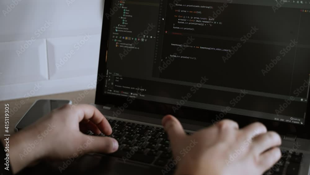 Men's hands press the keys of a laptop keyboard. A man writes a program ...