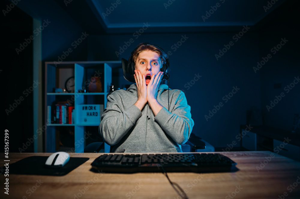 Foto de Portrait of a shocked gamer in casual clothes and a headset on ...