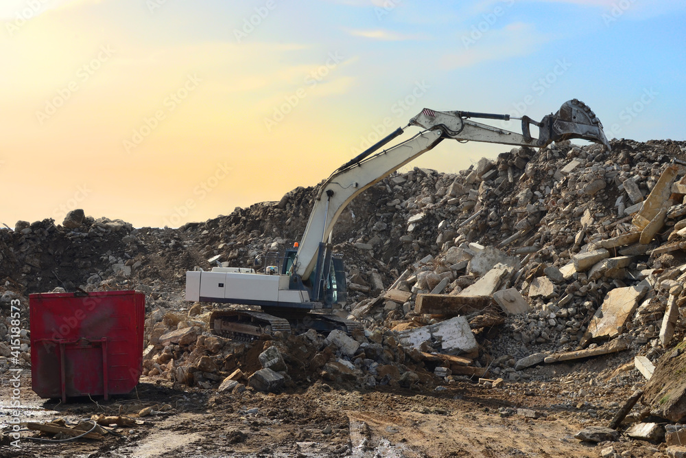 Recycling concrete and construction waste from demolition. Excavator at ...