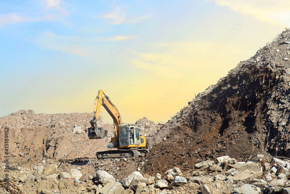 Recycling concrete and construction waste from demolition. Excavator at ...