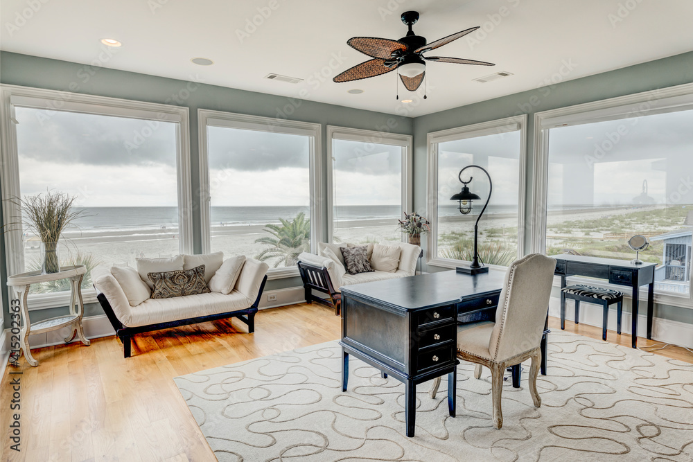 Luxury home office with large windows and a view of the ocean. Stock ...