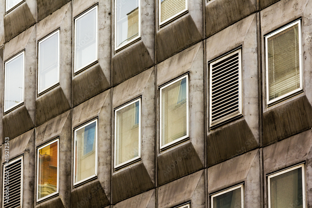 brutalist concrete window elements of office building with air vent ...