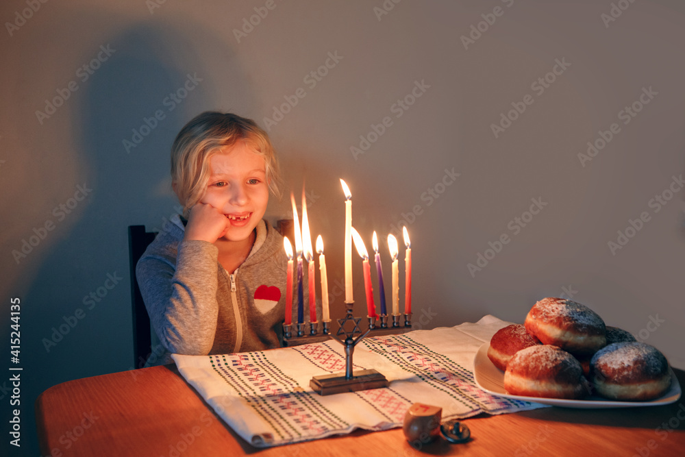 Girl lighting candles on menorah for traditional winter Jewish Hanukkah ...