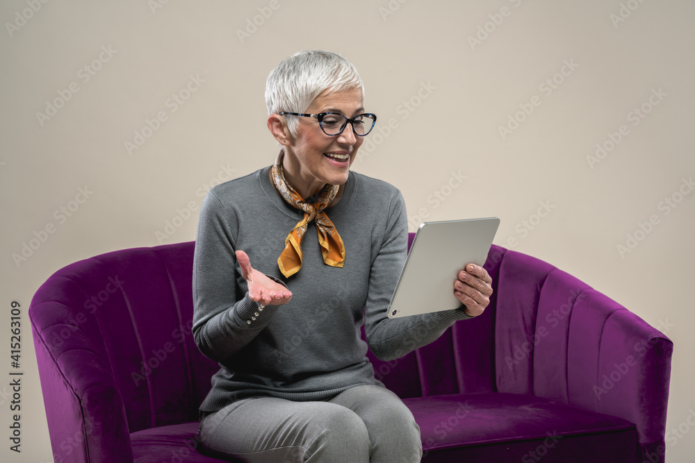 Senior female using tablet. Elderly lady having a video call during ...