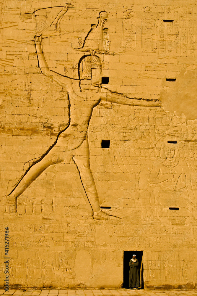 The massive stone pylon of Edfu Temple, carved with bas-reliefs showing ...