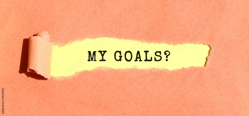 The text MY GOALS appearing on yellow paper behind torn color paper ...