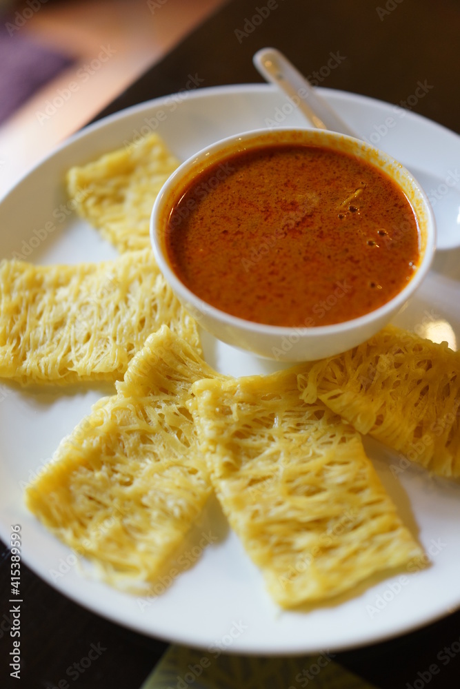 Roti Jala with chicken curry sauce. It is a popular Malay and ...