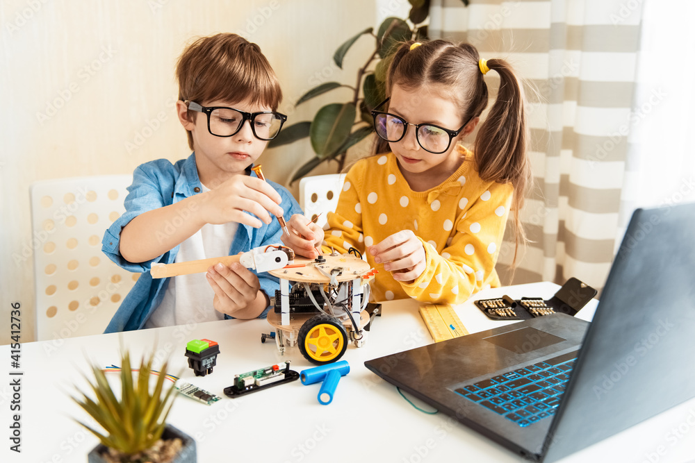 Happy kids programming and building science robotics project on his ...