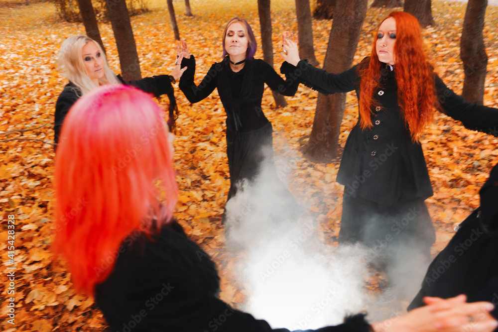 Coven of witches, a group of friends as witches on Halloween perform a ...