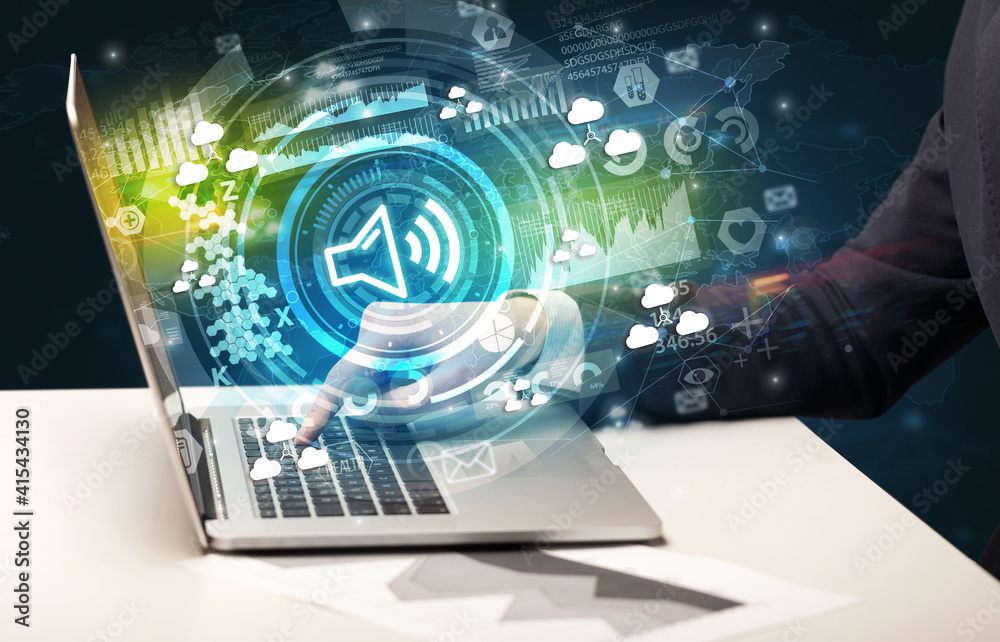 Business hand typing on a modern laptop with loud sound icon coming out ...