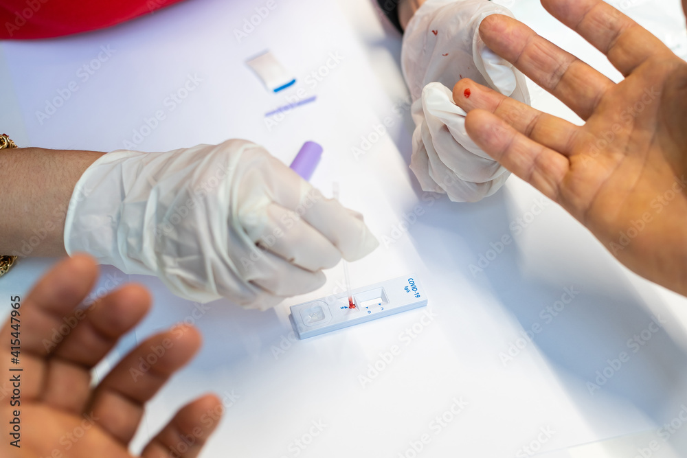Medical technician EMS doctor taking finger prick PRP patient blood ...