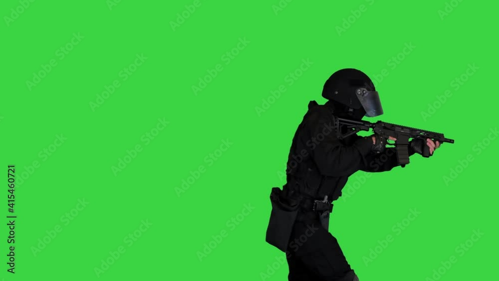 Policeman in black camouflage walking and shooting from the machine gun ...
