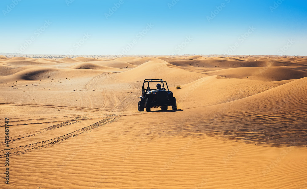 Buggy quad bike ride forward ahead at desert sand, leave tracks ...