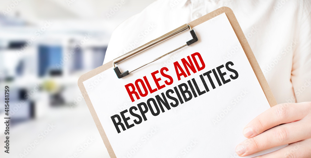 Text roles and responsibilities on white paper plate in businessman ...