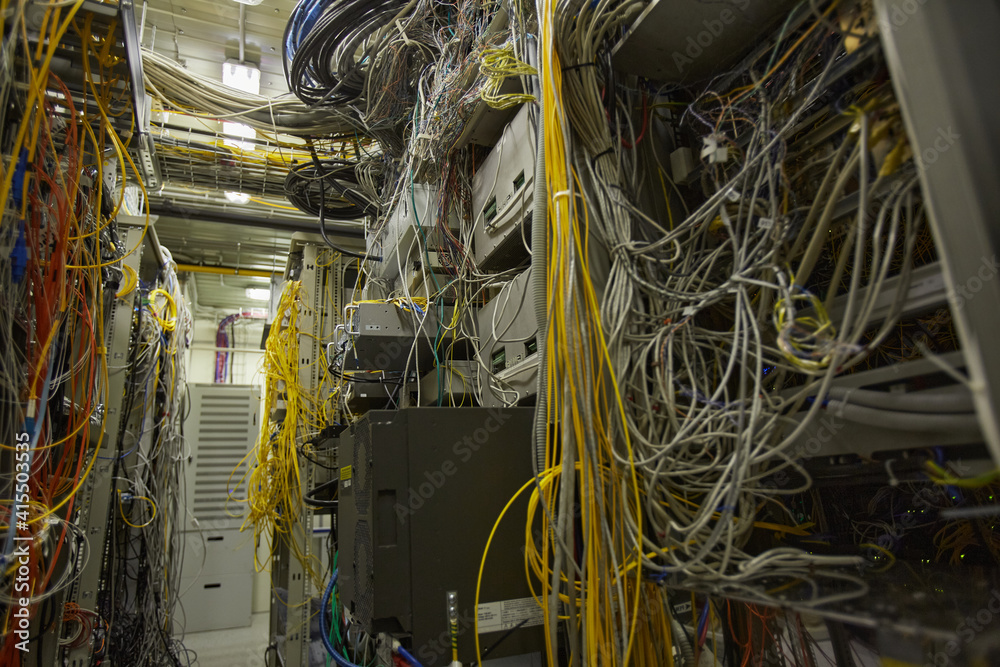 Background image of messy server room with internet cables and wires in ...