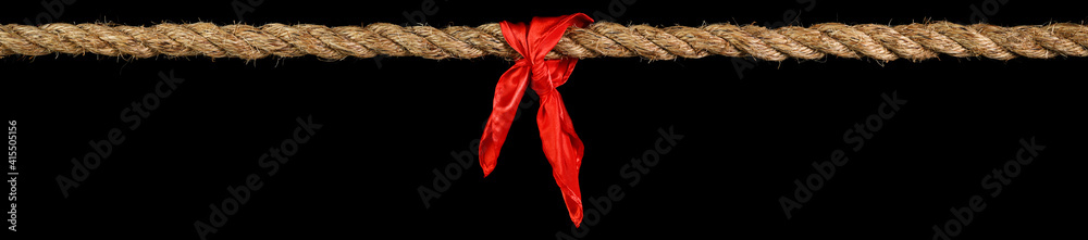 Long tug of war rope pulled tight, with red ribbon tie. Concept of ...