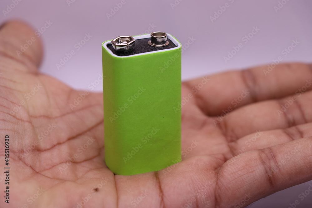 9v battery with green screen to print brand labels held in hand ...