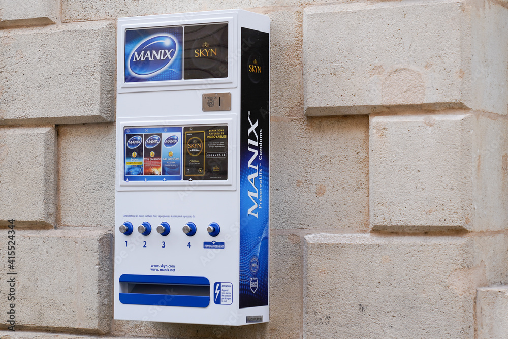 manix condoms automat machine on pharmacy street building wall facade ...