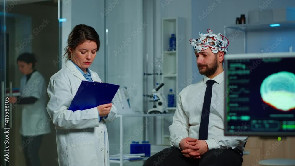 Man sitting on neurological chair with brainwave scanning headset while ...